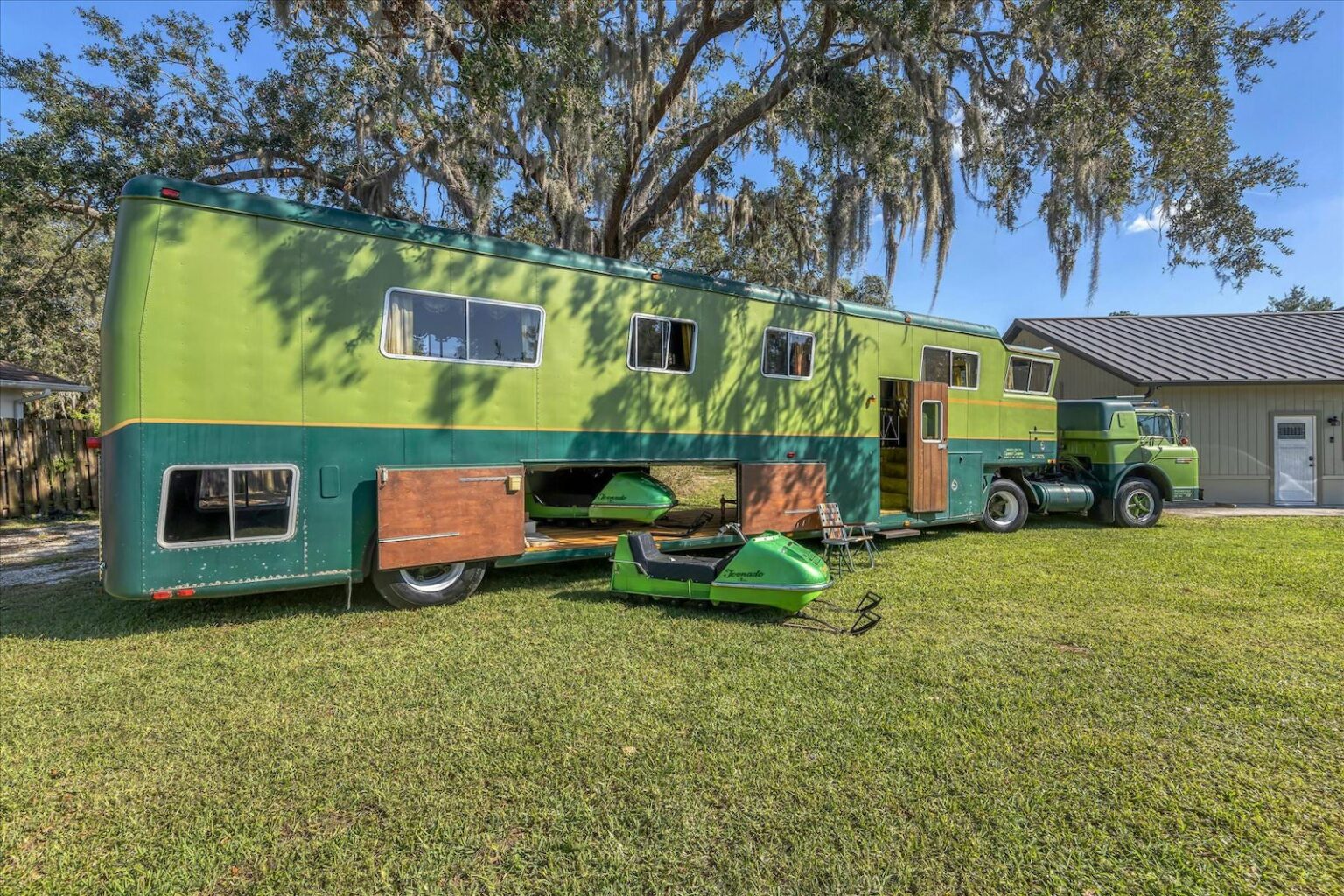 A Camelot Cruiser Motorhome With Matching Poloron Snowmobiles
