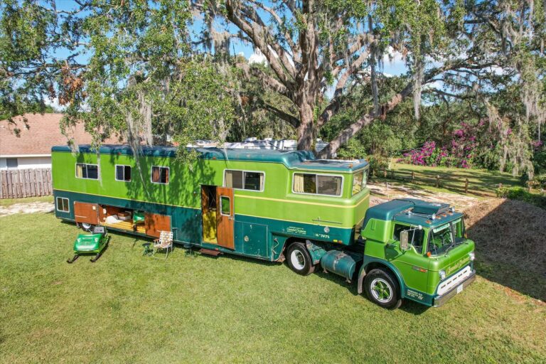 A Camelot Cruiser Motorhome With Matching Poloron Snowmobiles